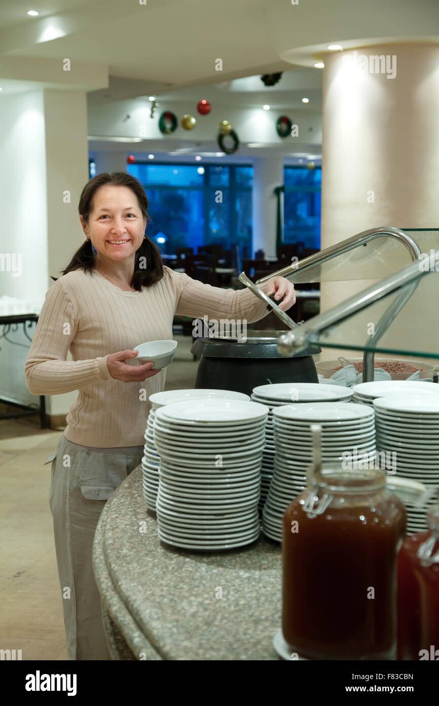 Female pour the soup on the buffet table Stock Photo - Alamy