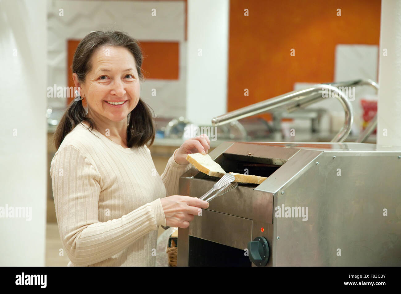 woman makes toast in toaster at hotel restaurant Stock Photo - Alamy