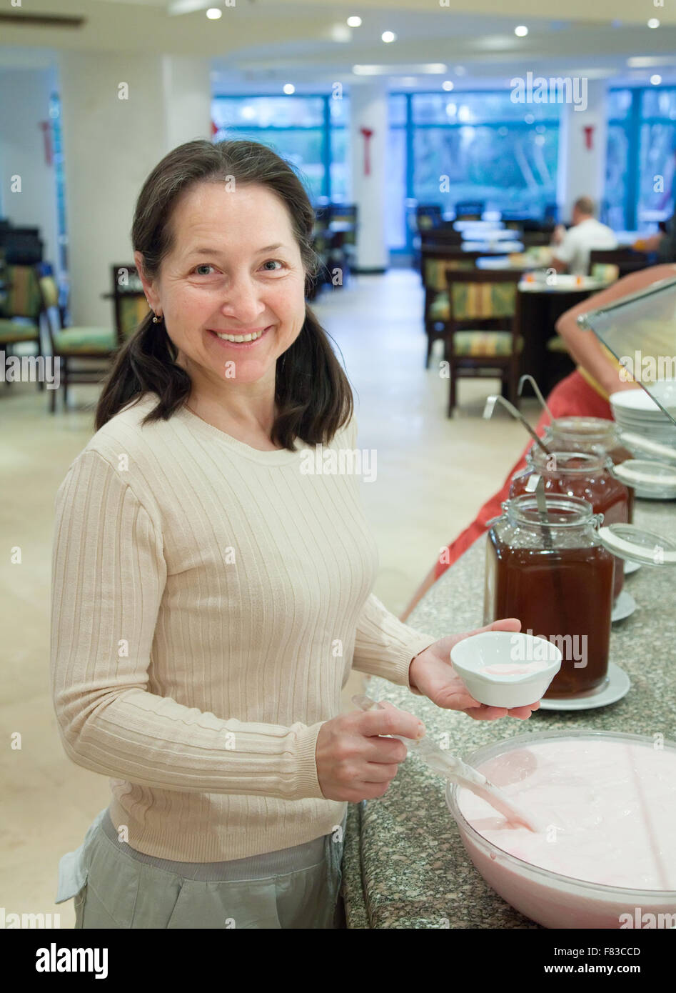 Woman takes milk food on the buffet table Stock Photo - Alamy