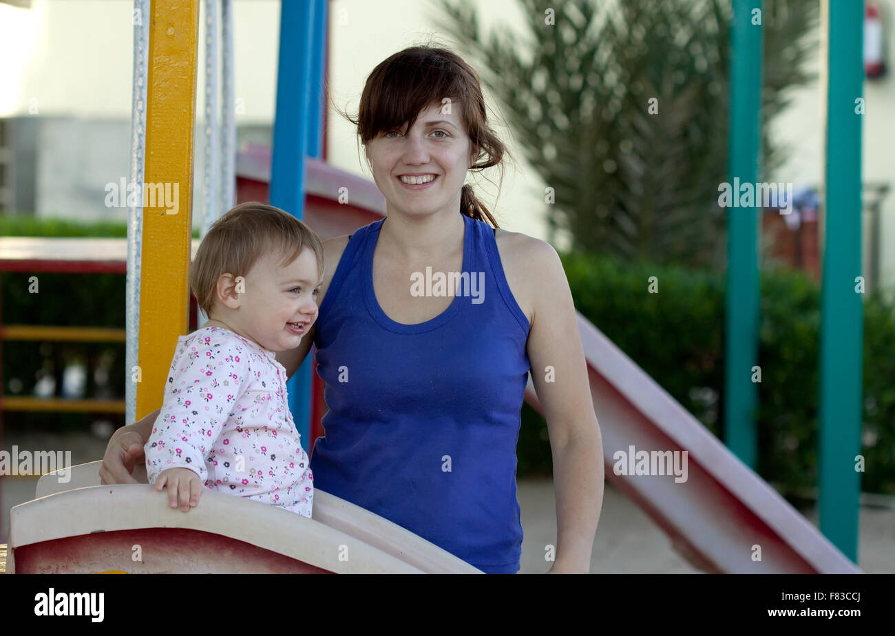 happy mother with toddler on slide playground area Stock Photo - Alamy