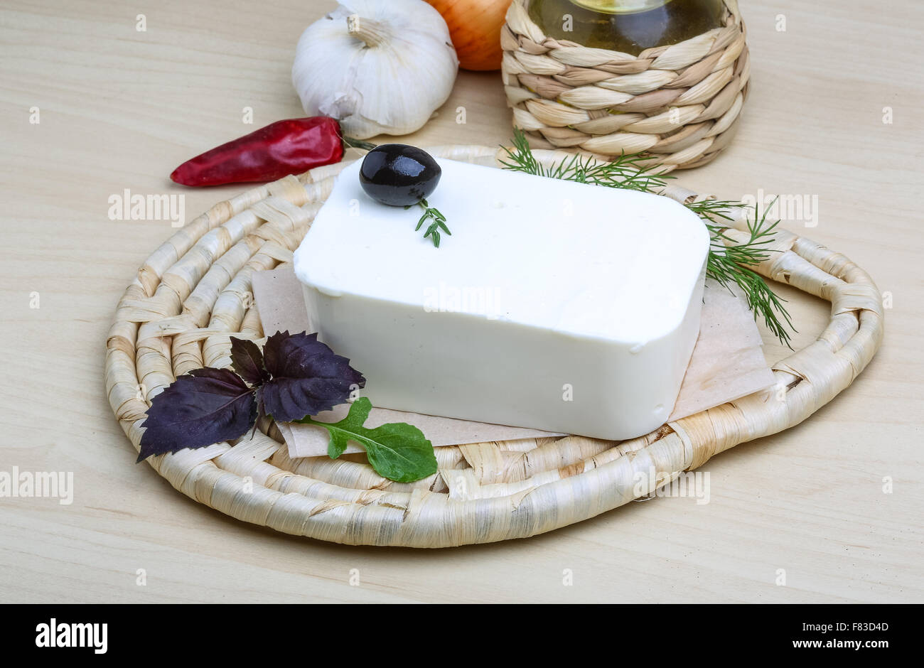 Feta cheese slice on the board with herbs Stock Photo - Alamy