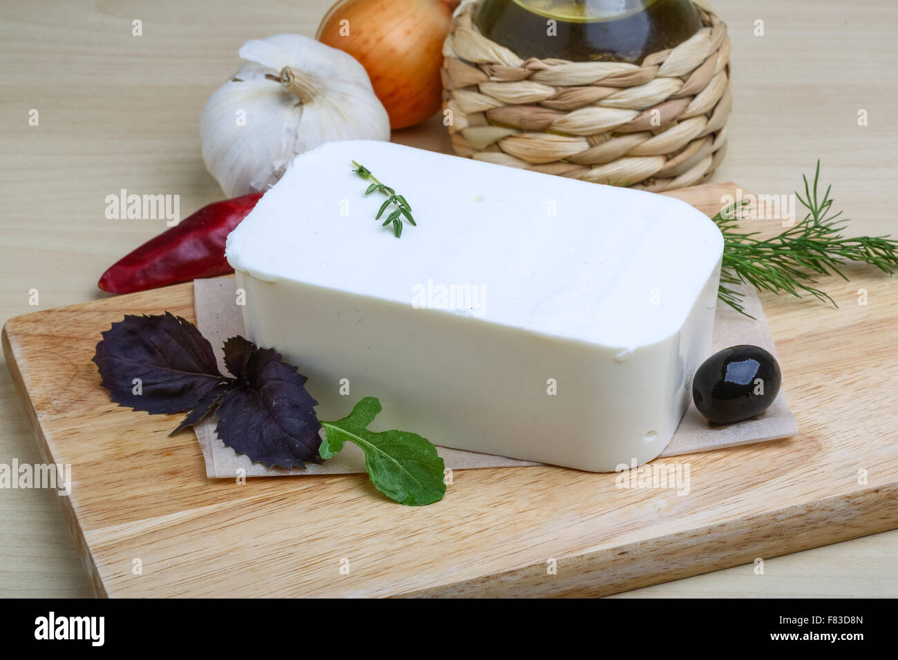 Feta cheese slice on the board with herbs Stock Photo - Alamy