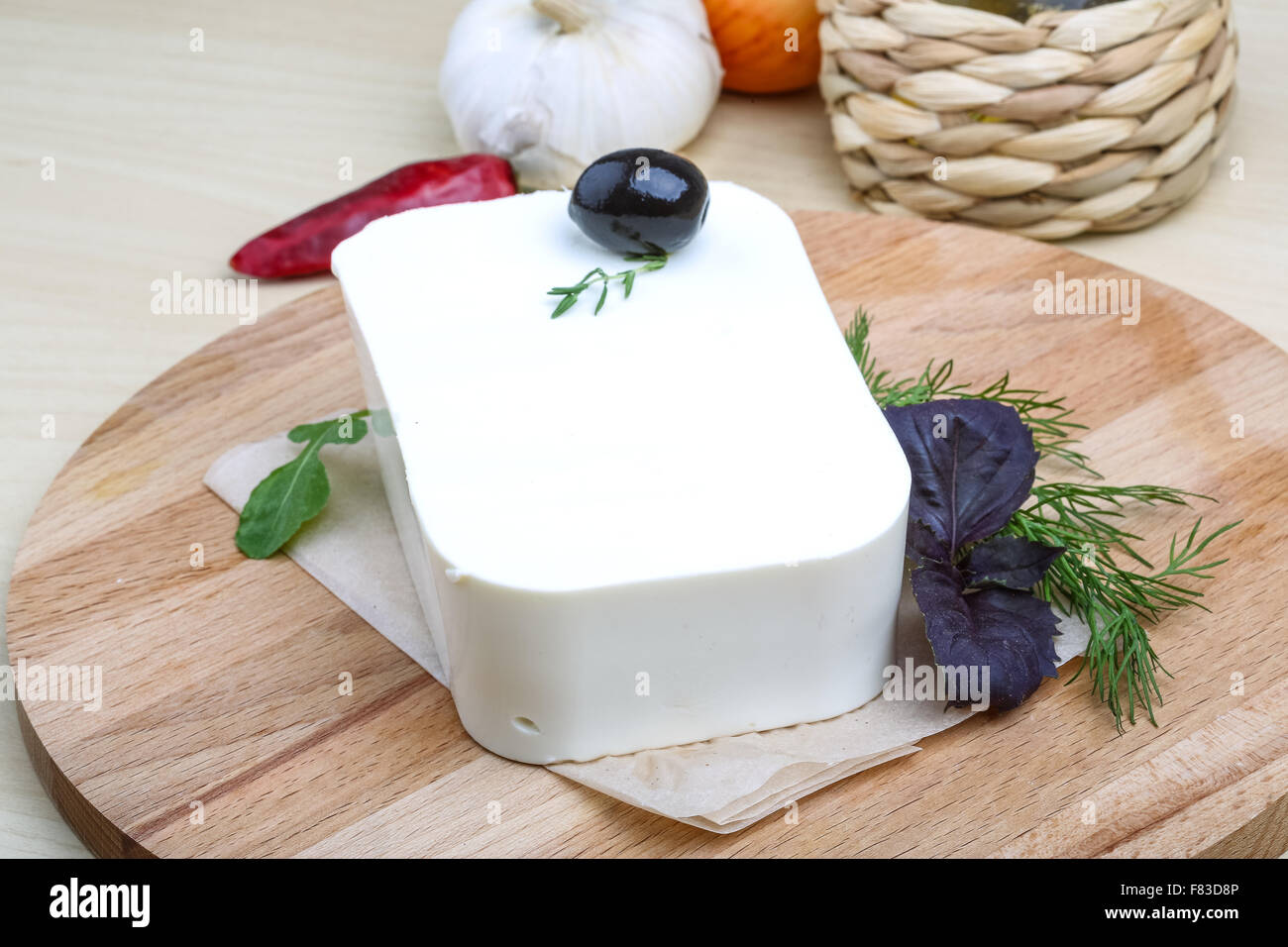 Feta cheese slice on the board with herbs Stock Photo - Alamy