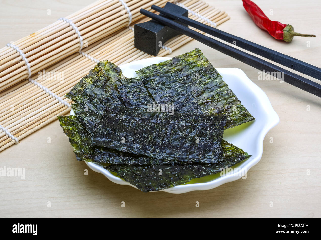 Nori sheets with sticks on the wood background Stock Photo - Alamy