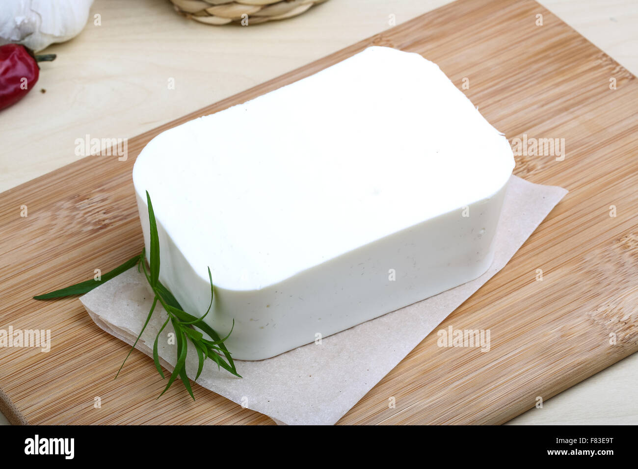 Feta cheese slice on the board with herbs Stock Photo - Alamy