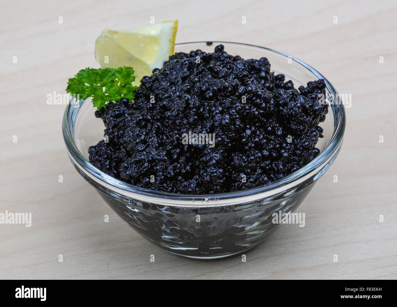 Luxury Black caviar with green herb and lemon Stock Photo - Alamy