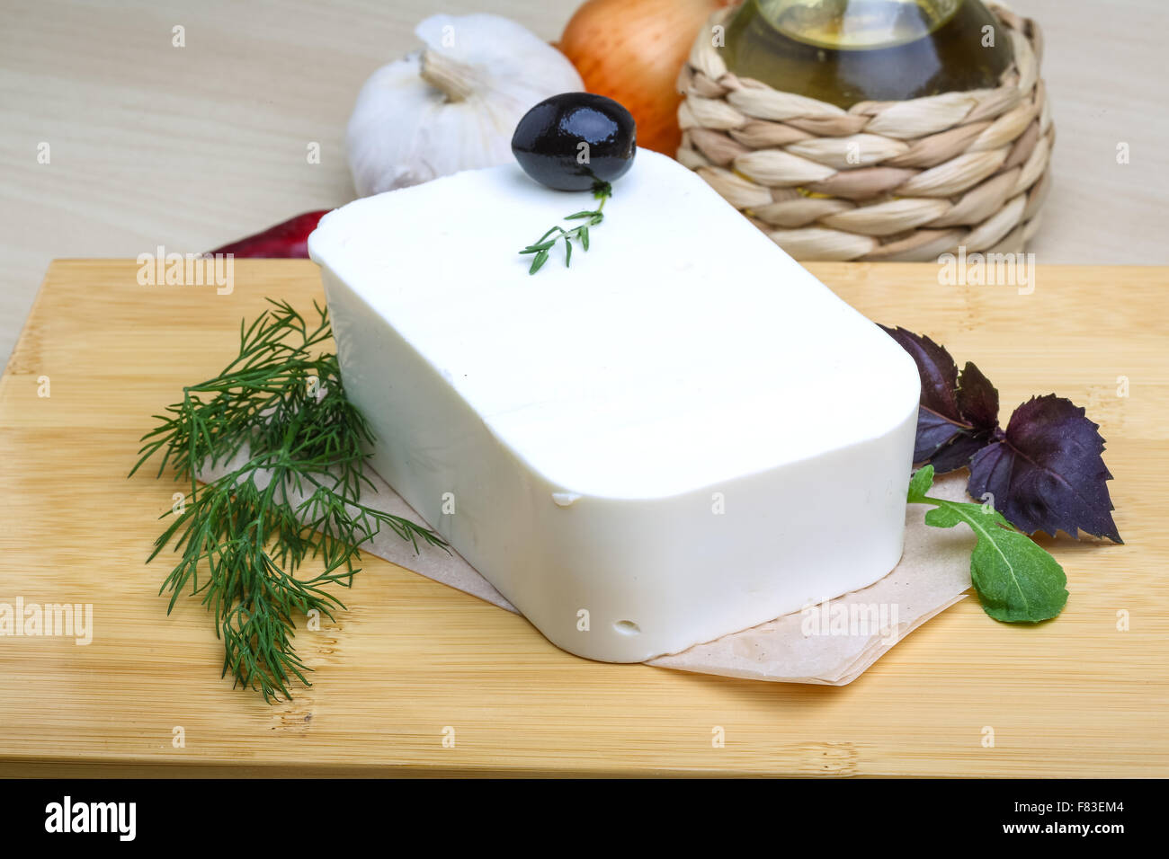 Feta cheese slice on the board with herbs Stock Photo - Alamy