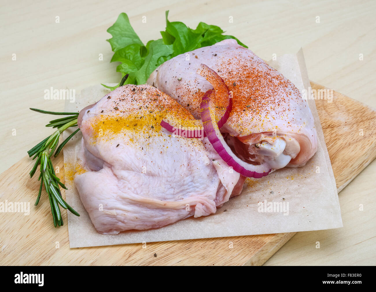 Two Raw chicken thights with herbs and spices Stock Photo - Alamy