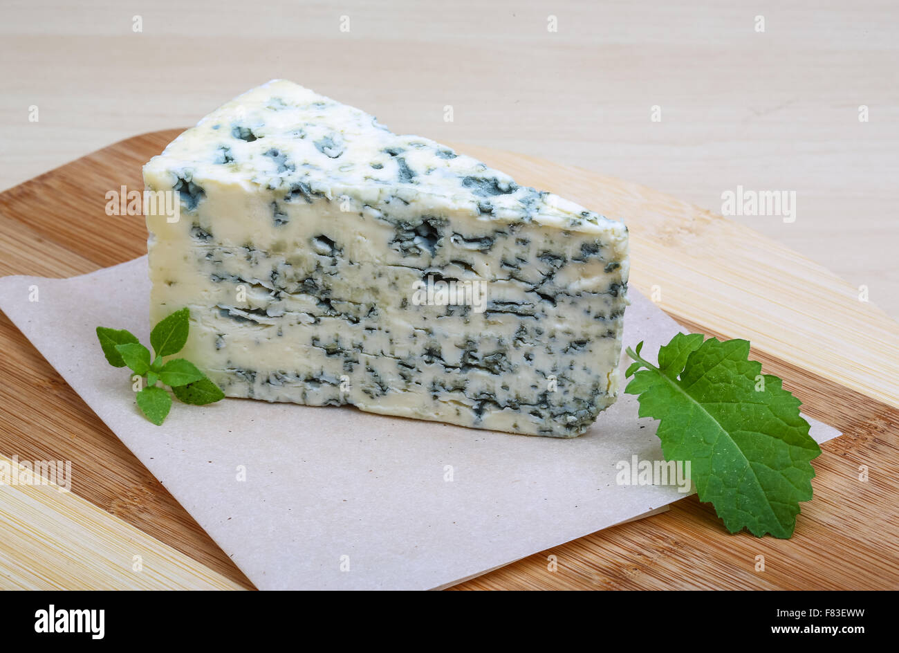 Dor Blue cheese with basil on the wood background Stock Photo - Alamy