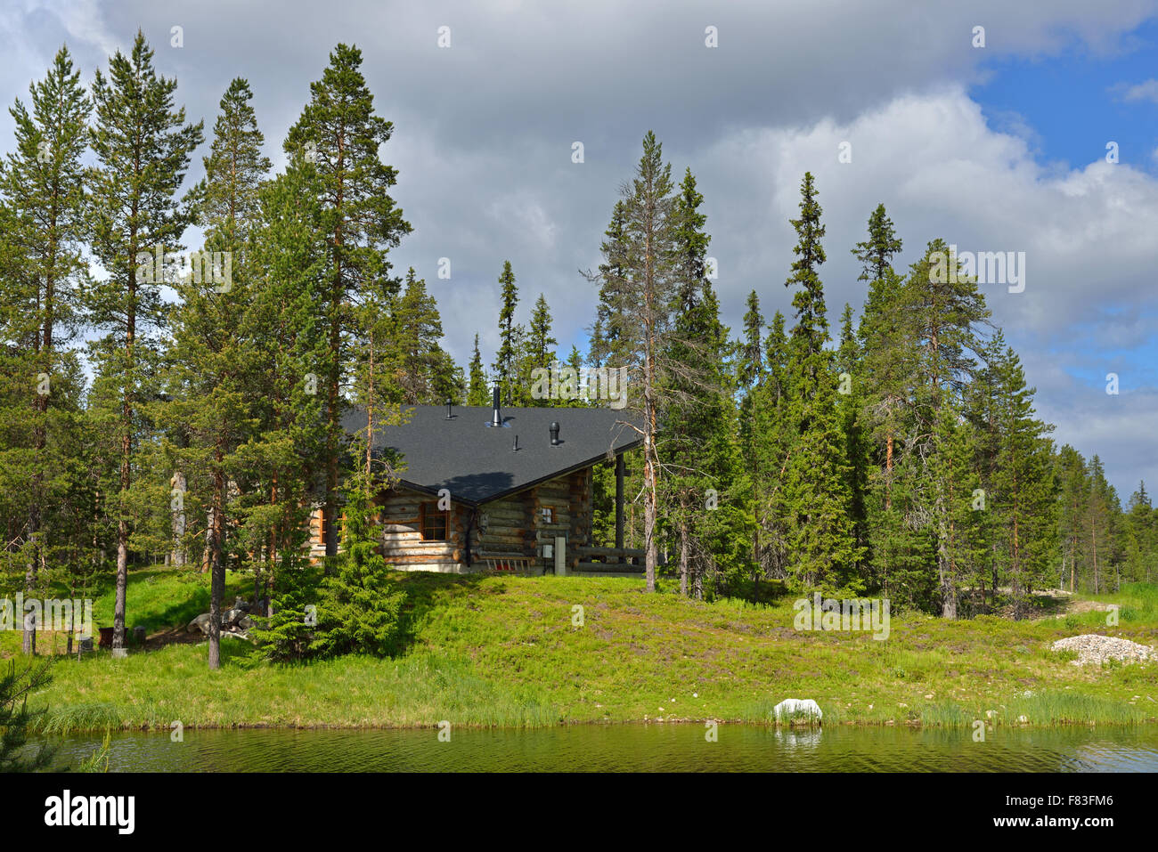 Comfortable log house on shore in northern forest, Finland, Lapland ...