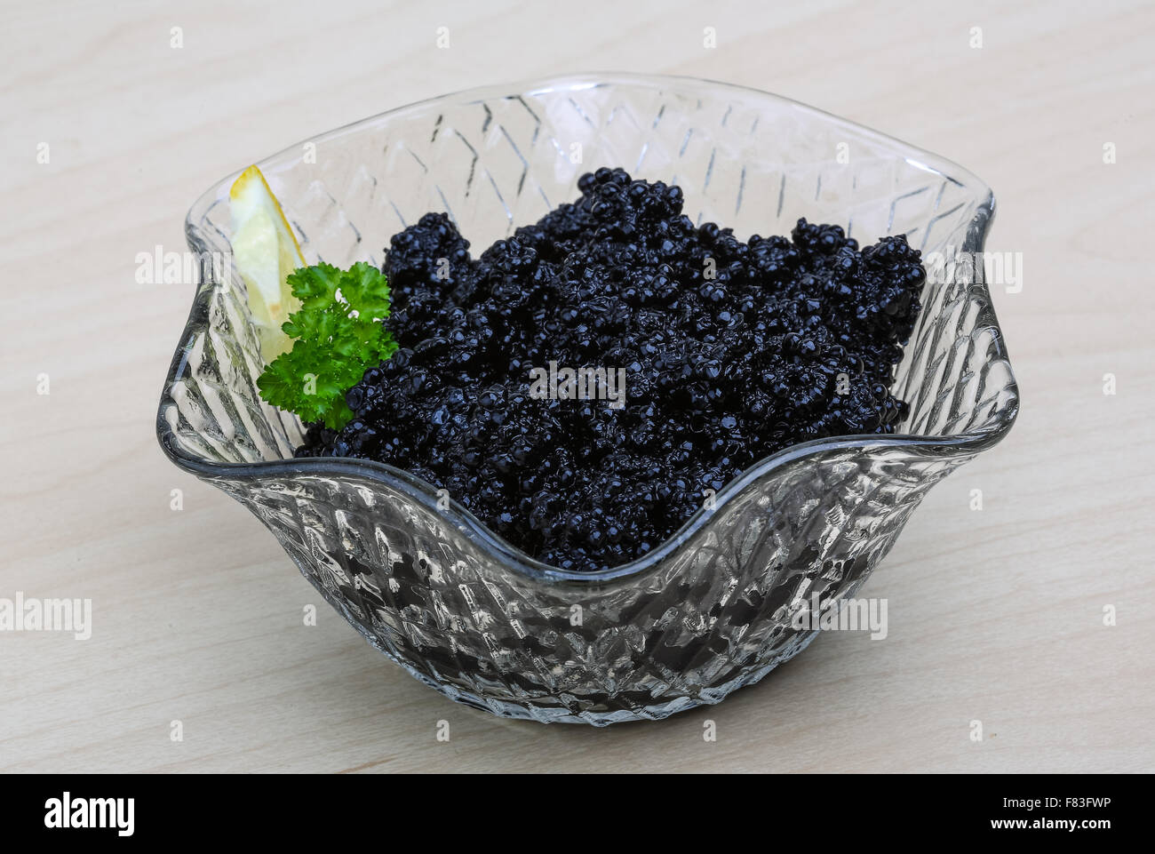 Luxury Black caviar with green herb and lemon Stock Photo - Alamy