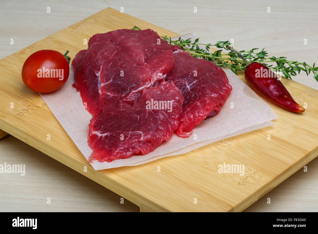 Raw beef steak - ready for cooking with thyme Stock Photo - Alamy
