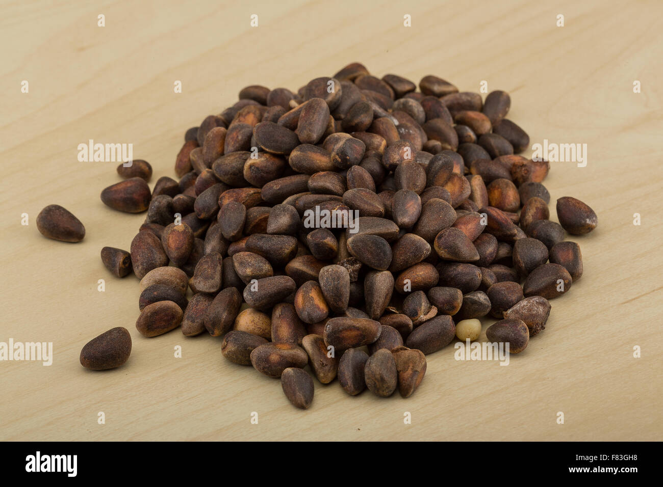 Brown Cedar nut on the wood background Stock Photo - Alamy