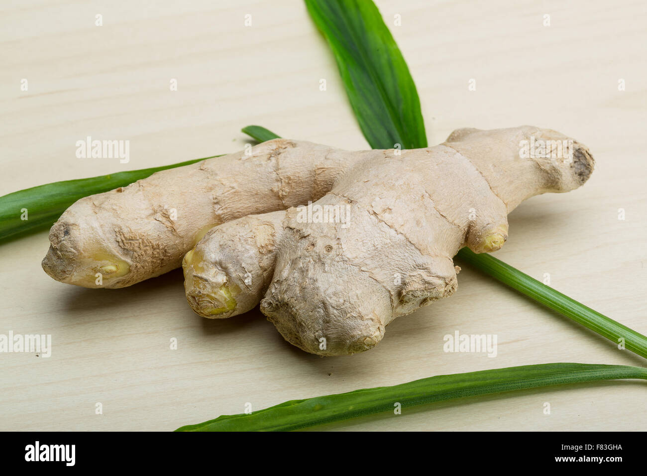 Ginger root on the wood background with leaves Stock Photo - Alamy