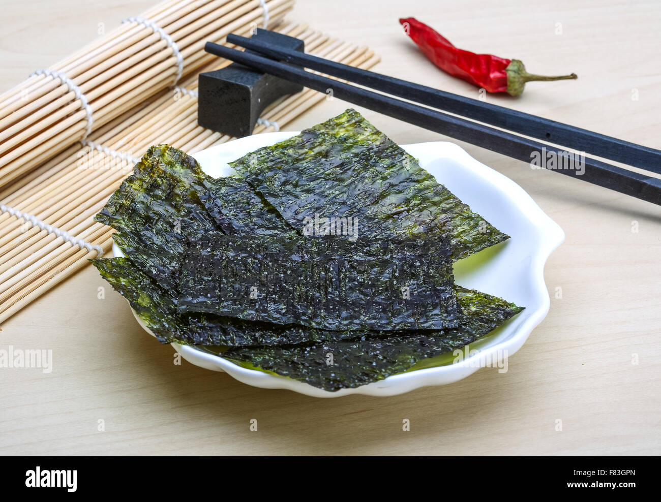 Nori sheets with sticks on the wood background Stock Photo - Alamy