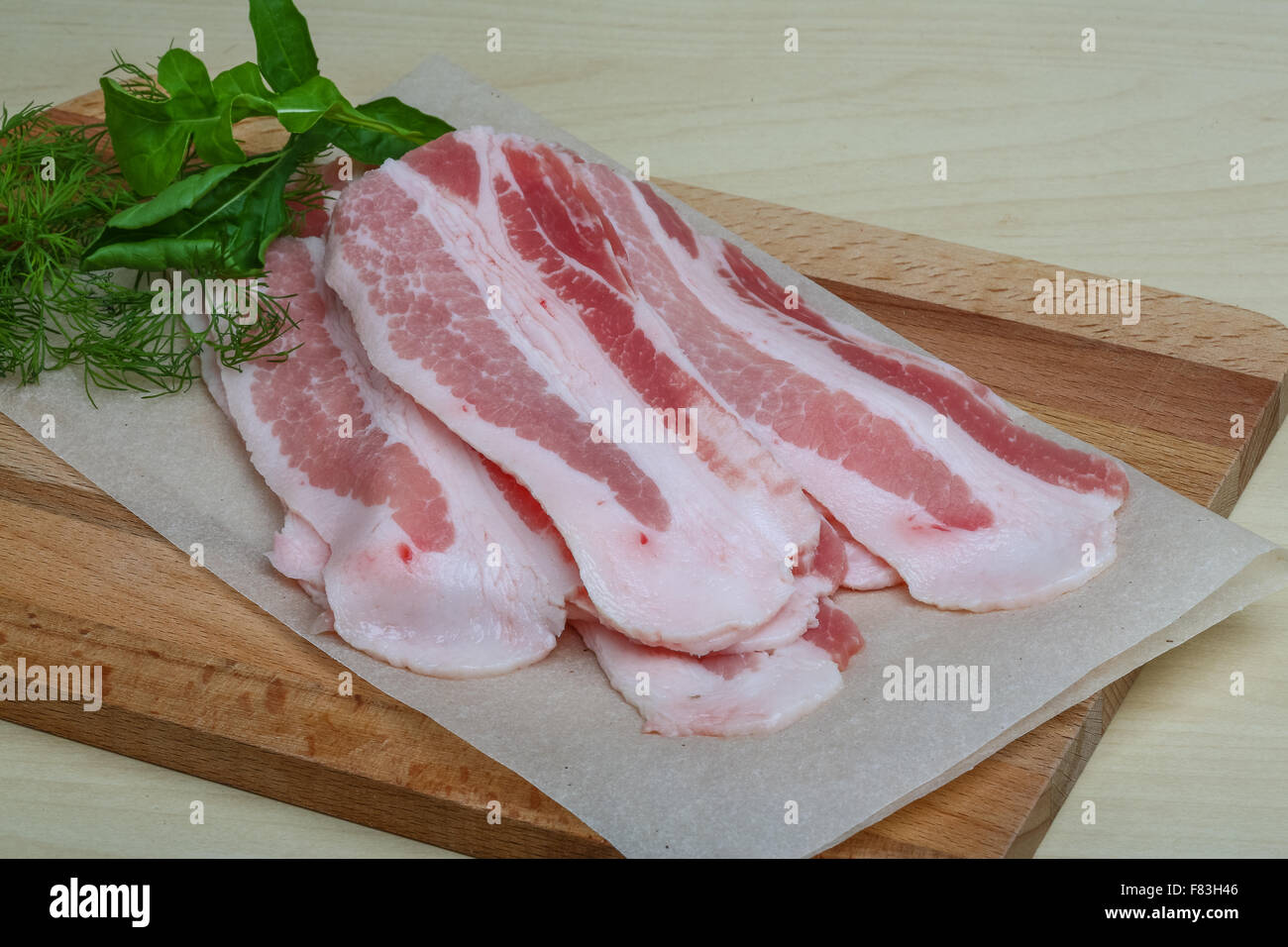Raw bacon with green herb on the wood background Stock Photo - Alamy