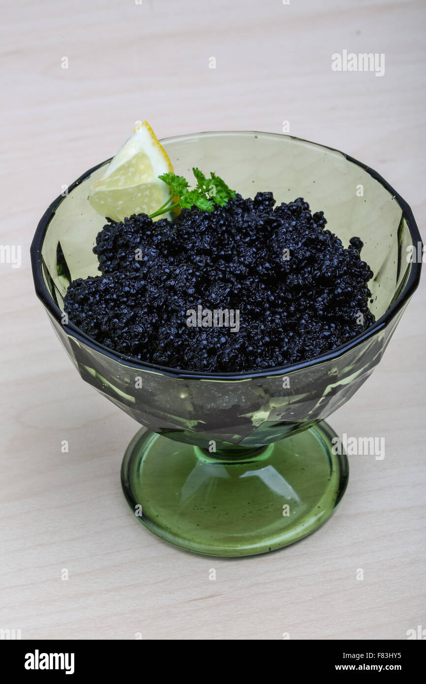 Luxury Black caviar with green herb and lemon Stock Photo - Alamy