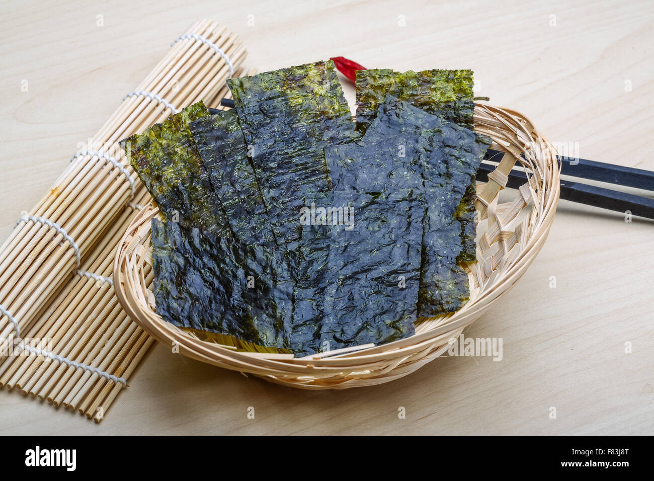Nori sheets with sticks on the wood background Stock Photo - Alamy