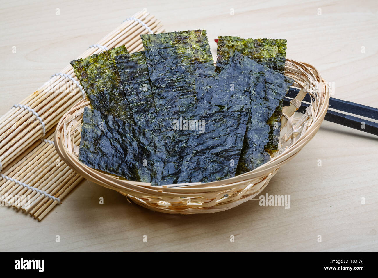 Nori sheets with sticks on the wood background Stock Photo - Alamy