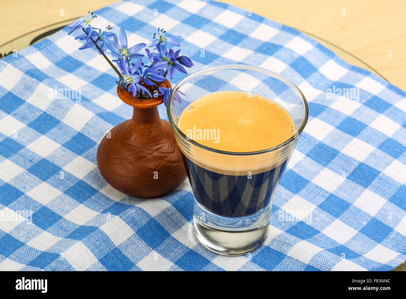 Hot Espresso coffee with blue spring flowers Stock Photo - Alamy