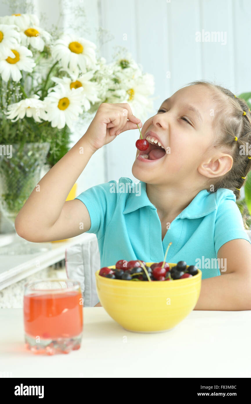 Cute Little girl eating cherries Stock Photo - Alamy