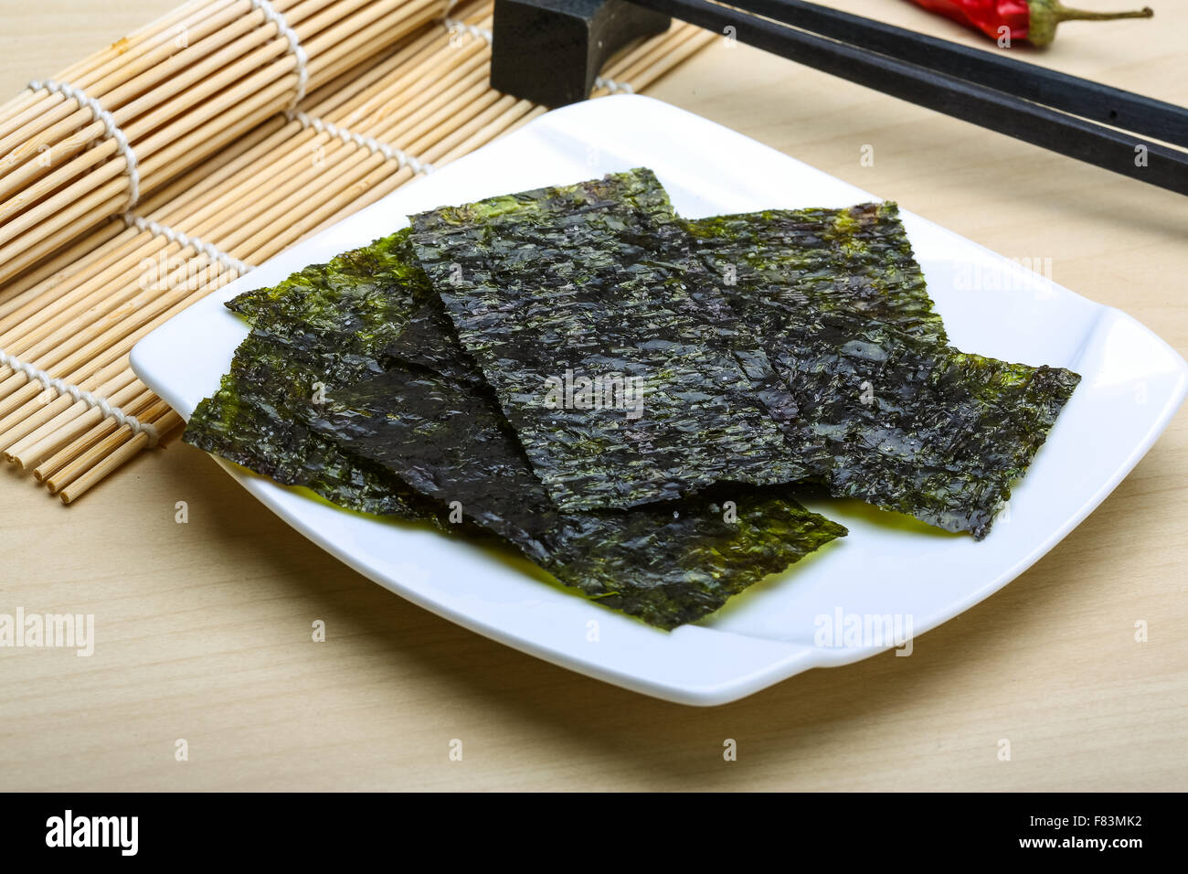 Nori sheets with sticks on the wood background Stock Photo - Alamy