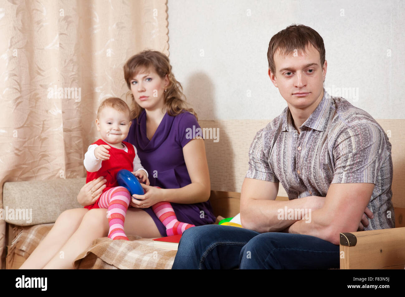 Family of three having quarrel at home Stock Photo - Alamy