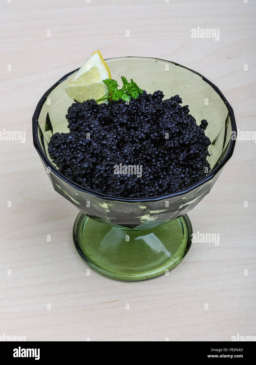 Luxury Black caviar with green herb and lemon Stock Photo - Alamy