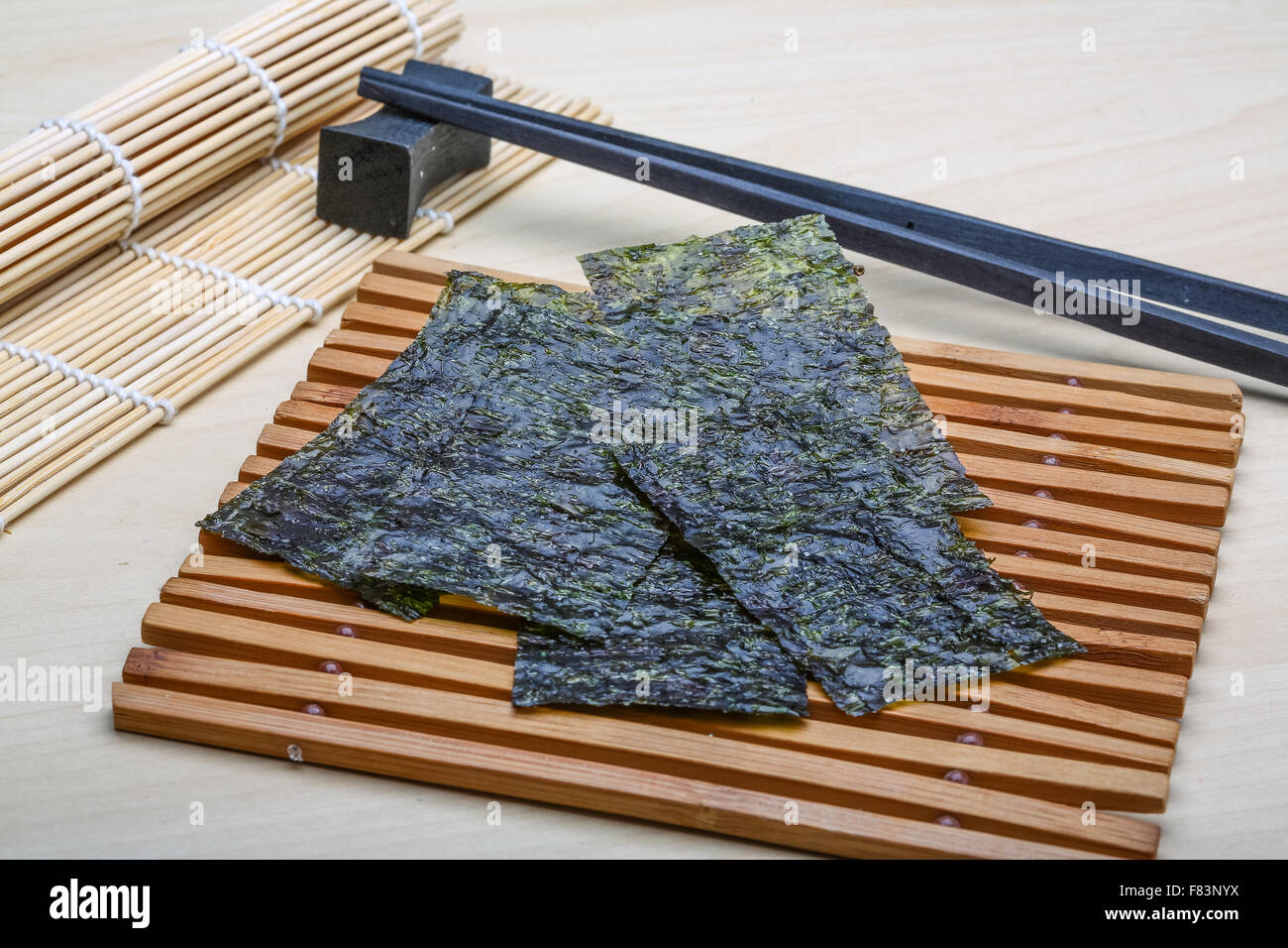 Nori sheets with sticks on the wood background Stock Photo - Alamy