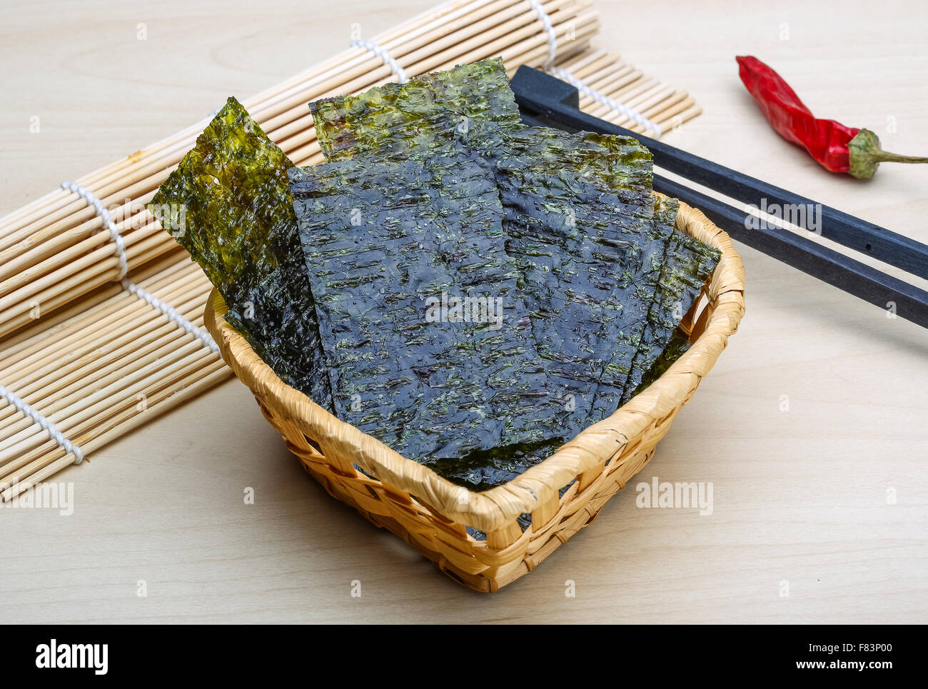Nori sheets with sticks on the wood background Stock Photo - Alamy