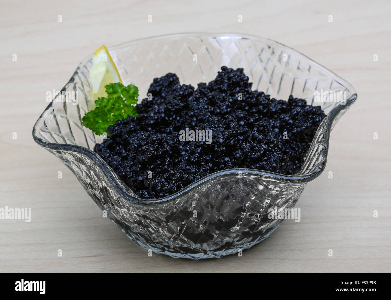 Luxury Black caviar with green herb and lemon Stock Photo - Alamy
