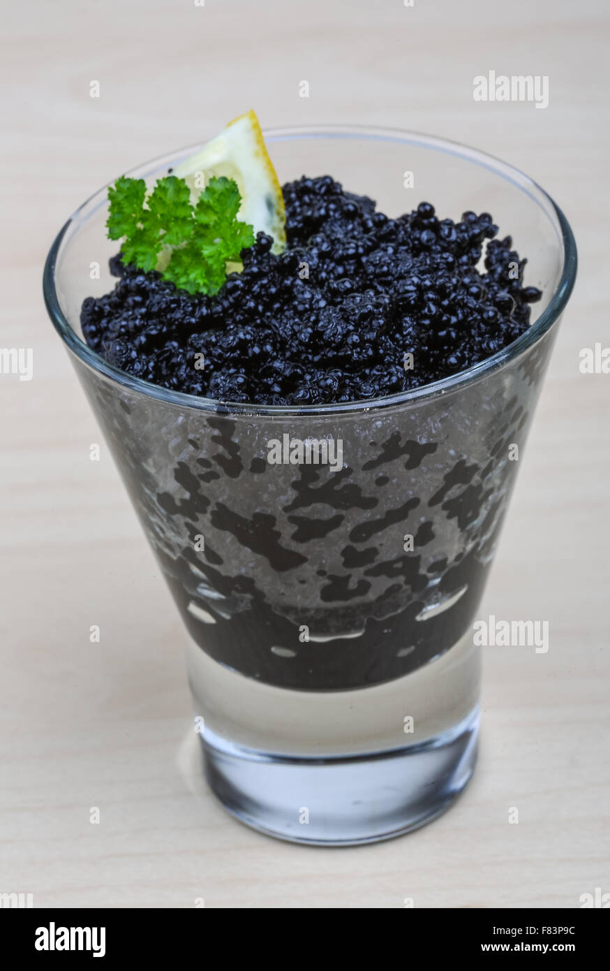 Luxury Black caviar with green herb and lemon Stock Photo - Alamy