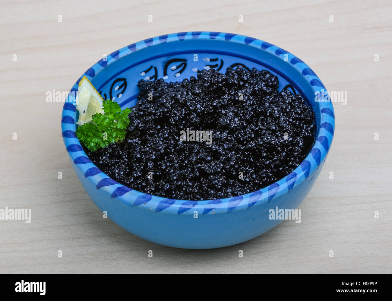 Luxury Black caviar with green herb and lemon Stock Photo - Alamy