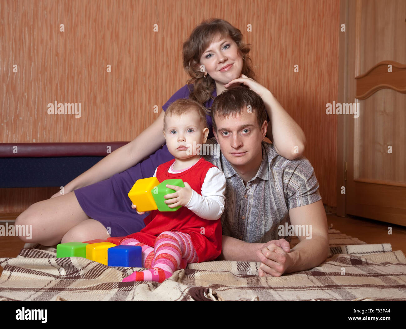 parents and child relaxing at home on floor Stock Photo - Alamy