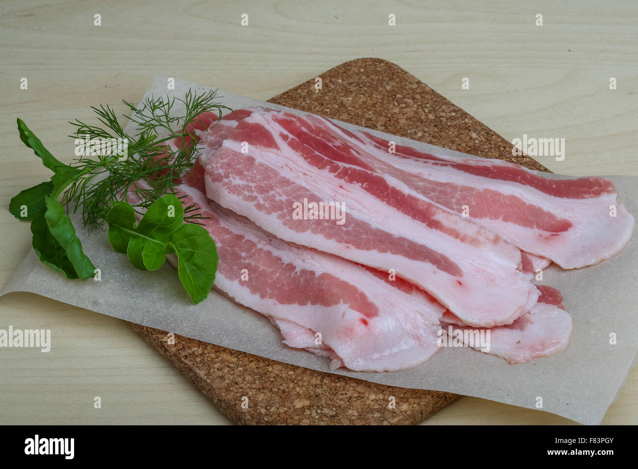 Raw bacon with green herb on the wood background Stock Photo - Alamy