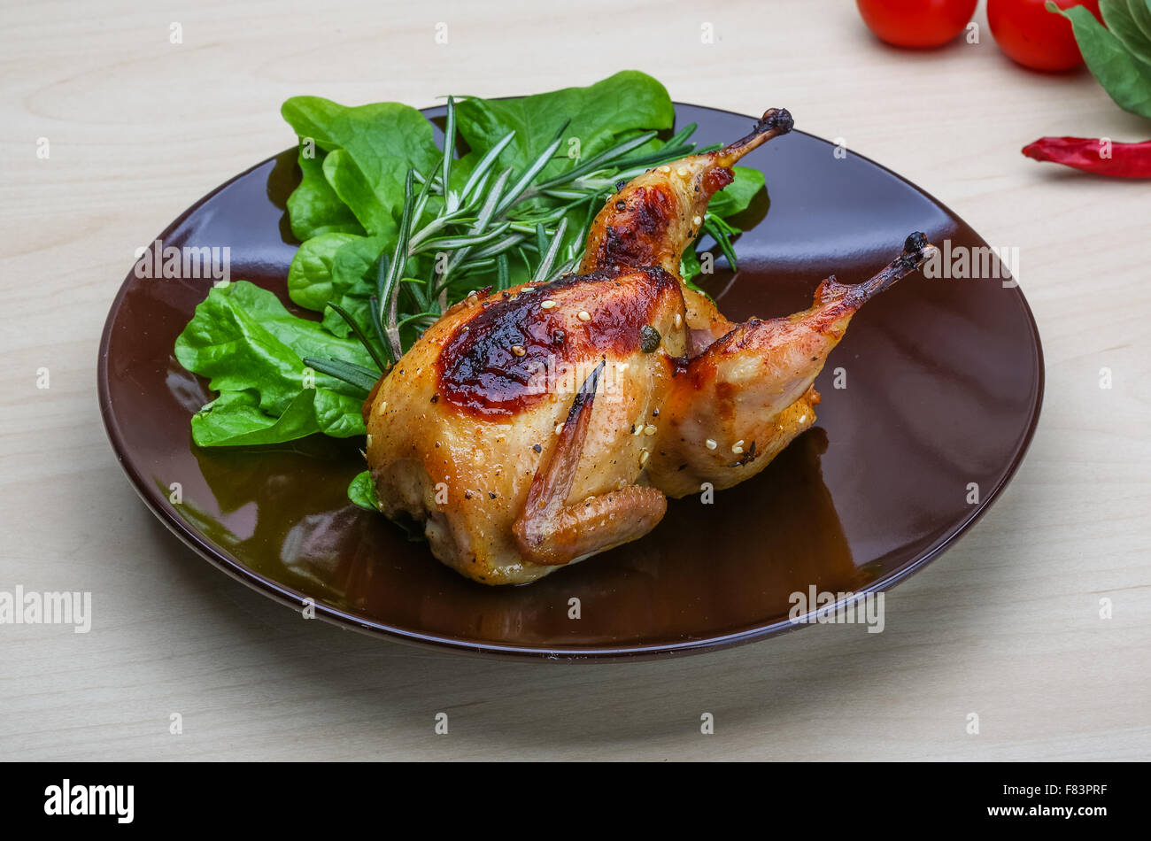 Roasted Quail with rosemary and spices on the wood background Stock ...