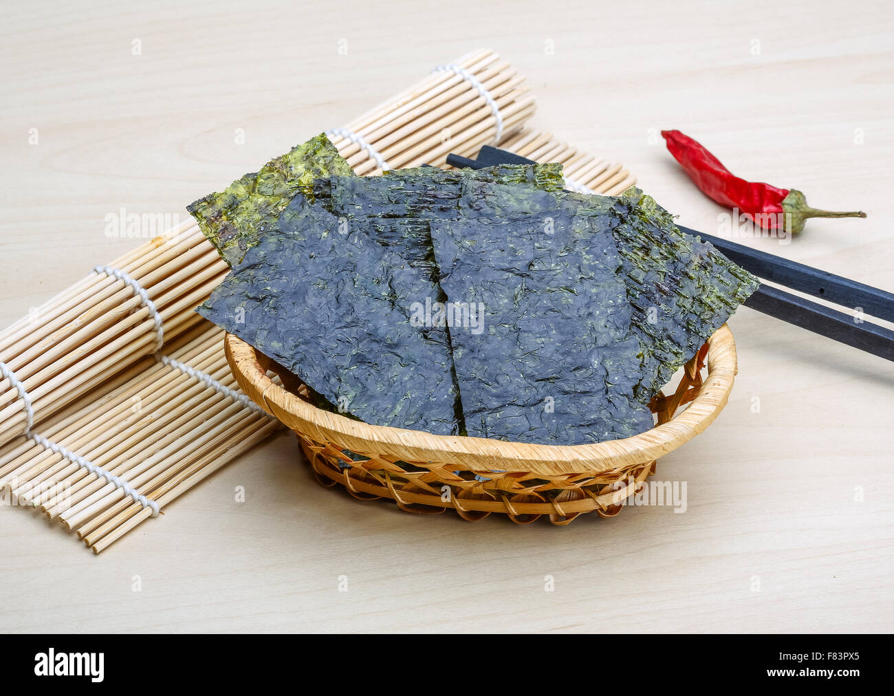 Nori sheets with sticks on the wood background Stock Photo - Alamy