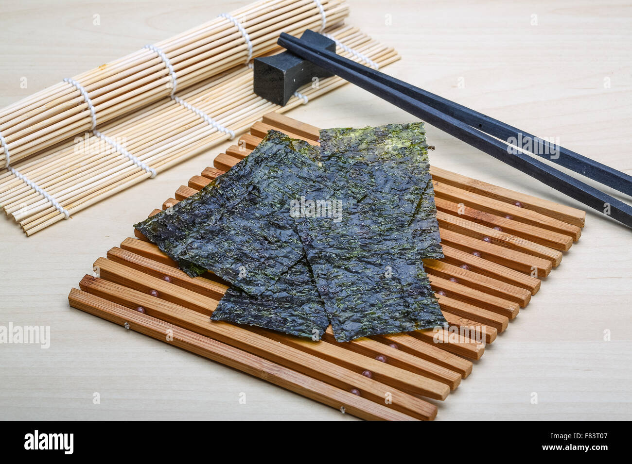 Nori sheets with sticks on the wood background Stock Photo - Alamy