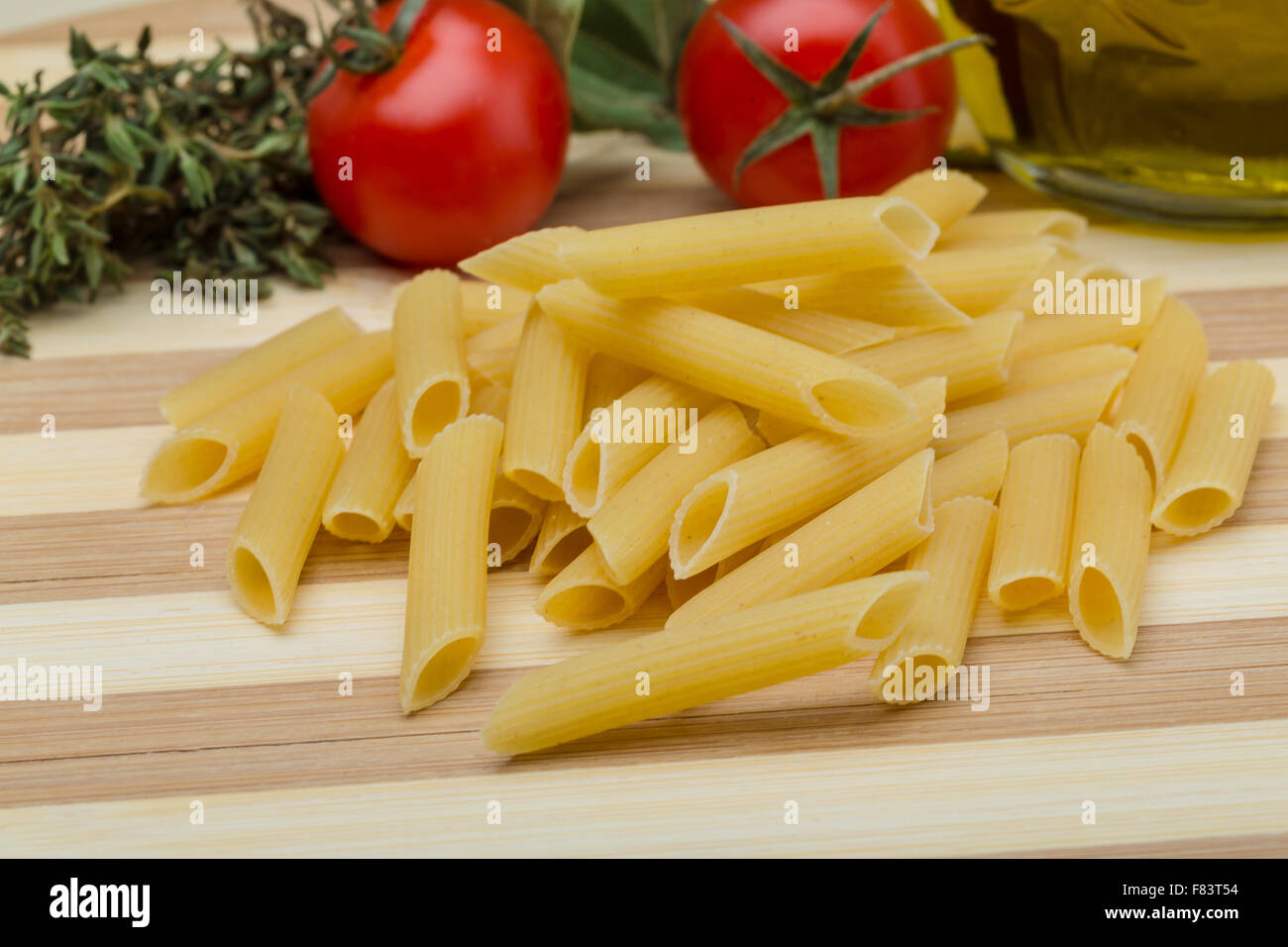 Raw penne pasta on the wood background Stock Photo - Alamy