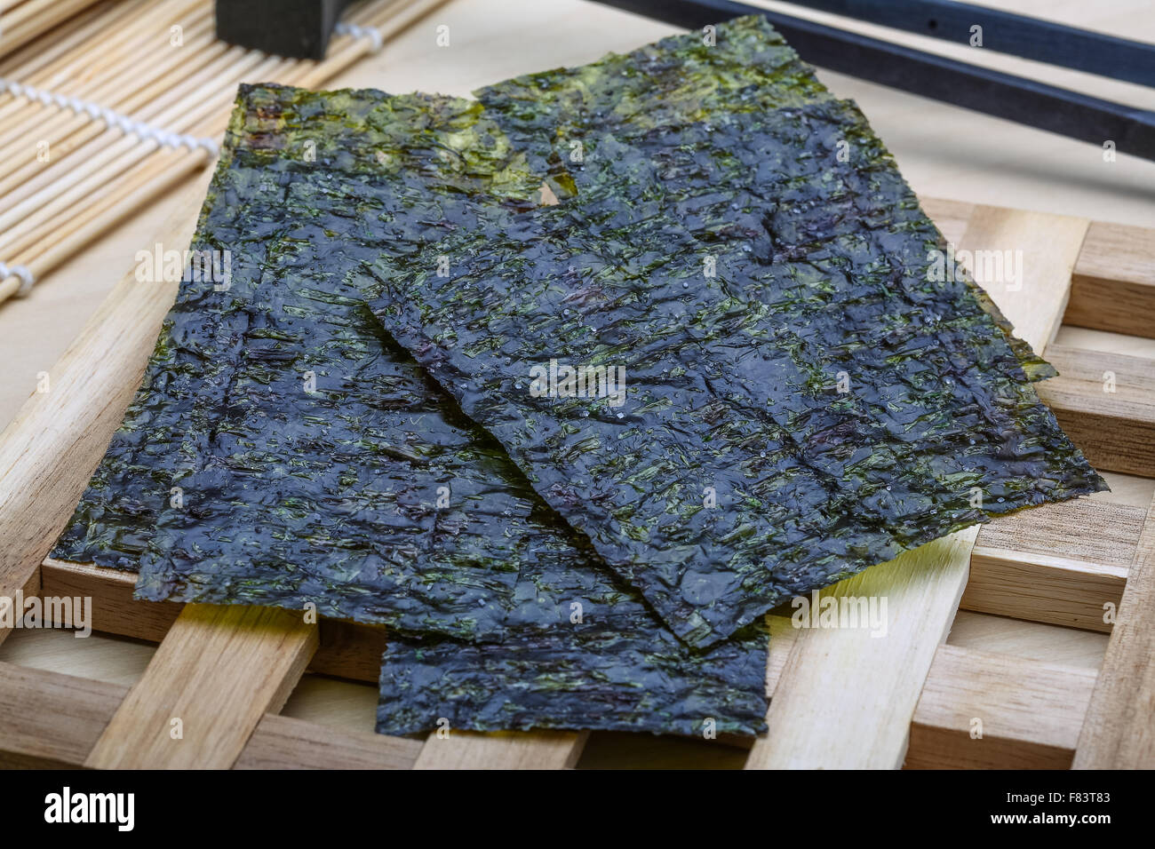 Nori sheets with sticks on the wood background Stock Photo - Alamy