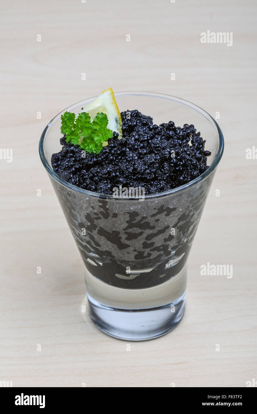 Luxury Black caviar with green herb and lemon Stock Photo - Alamy