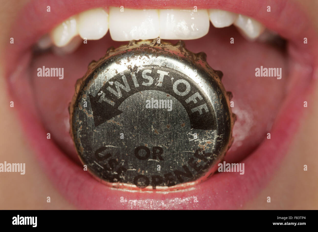 Twist off bottle cap in mouth Stock Photo - Alamy