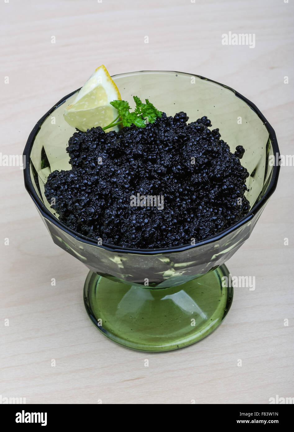 Luxury Black caviar with green herb and lemon Stock Photo - Alamy