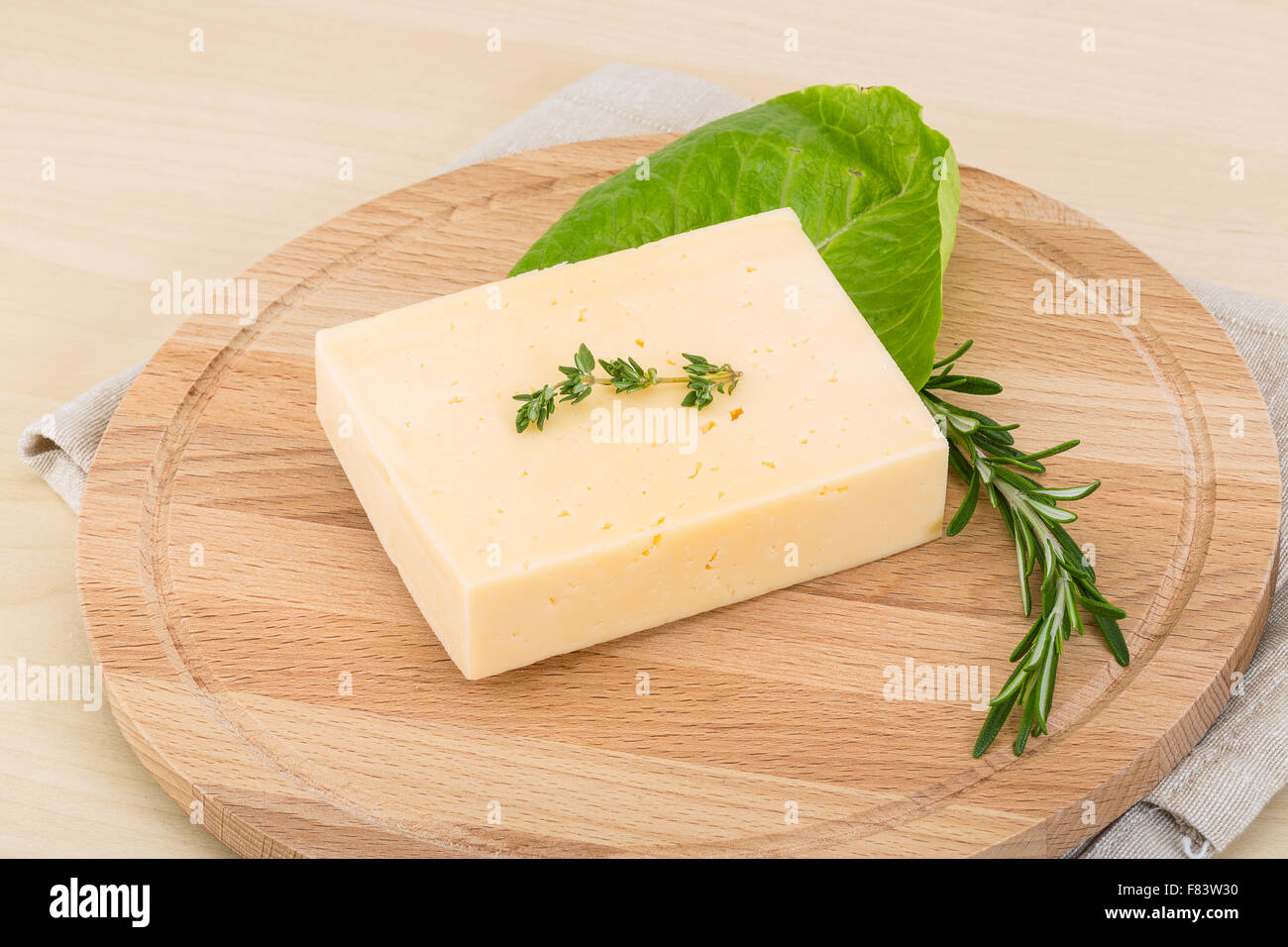 Yellow cheese brick with rosemary and thyme Stock Photo - Alamy