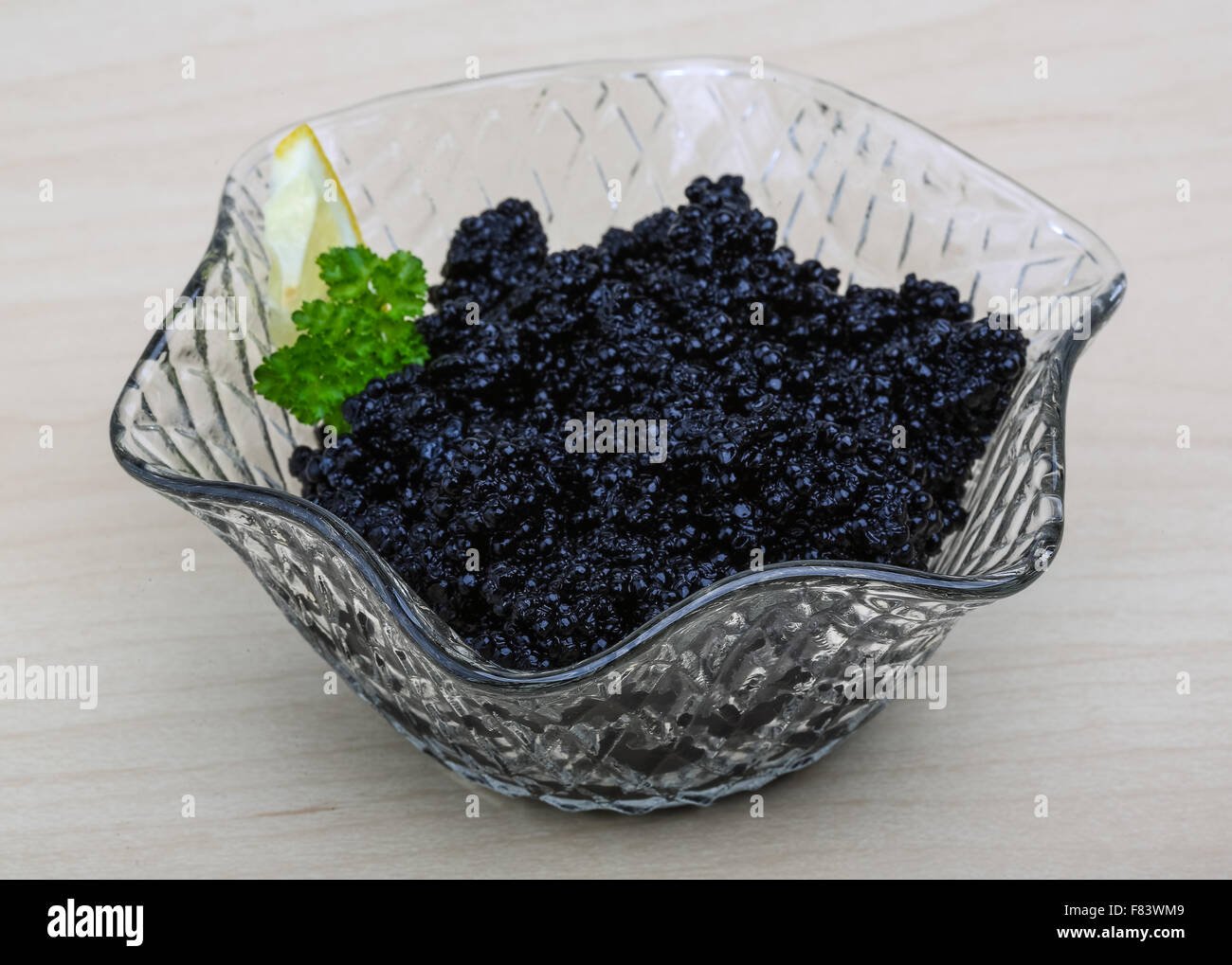 Luxury Black caviar with green herb and lemon Stock Photo - Alamy