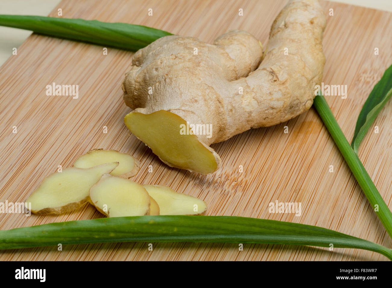 Ginger root on the wood background with leaves Stock Photo - Alamy