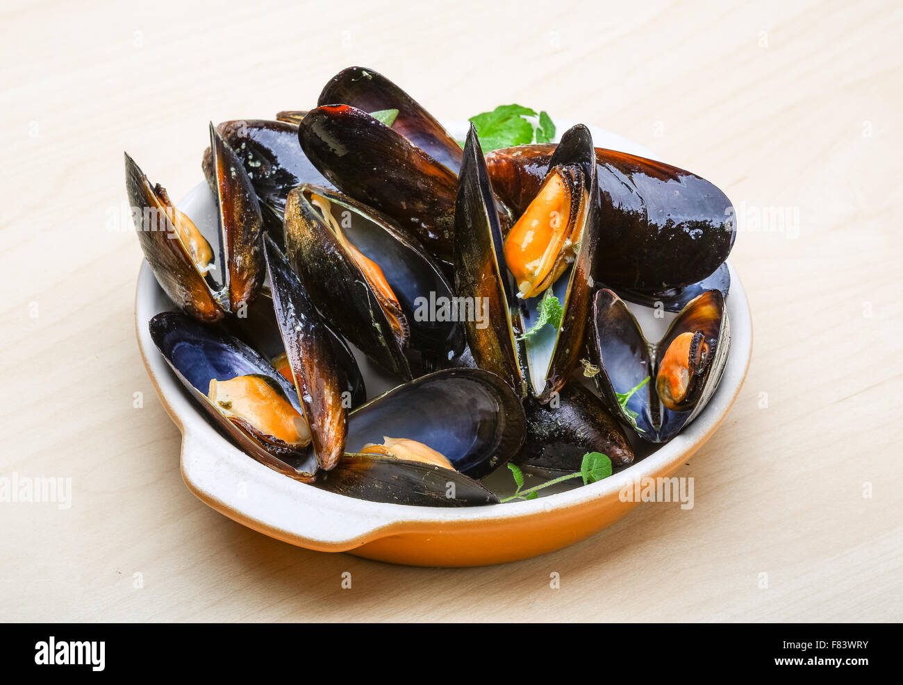 Fresh tasty Boiled mussels with herbs on wood background Stock Photo ...