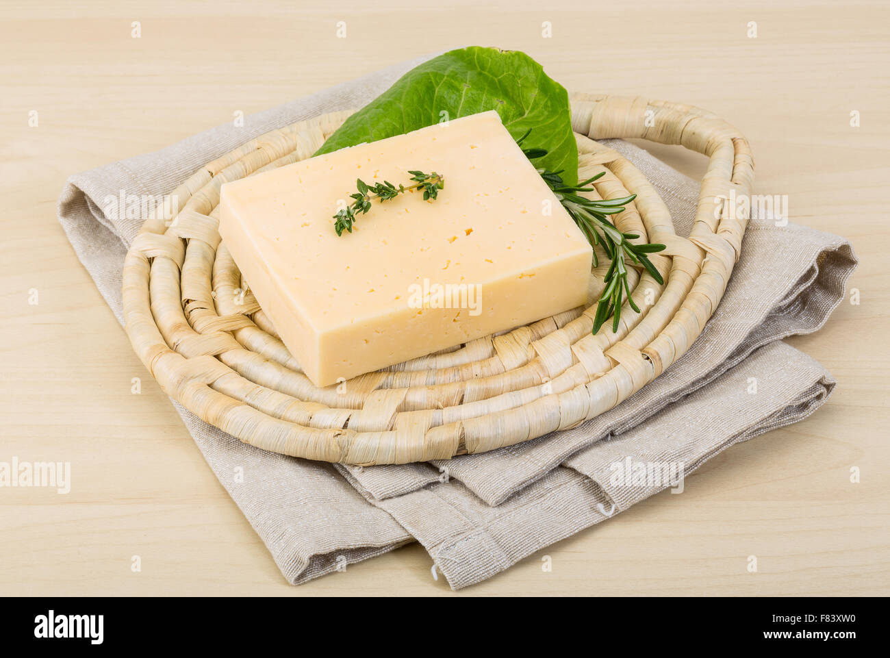 Yellow cheese brick with rosemary and thyme Stock Photo - Alamy