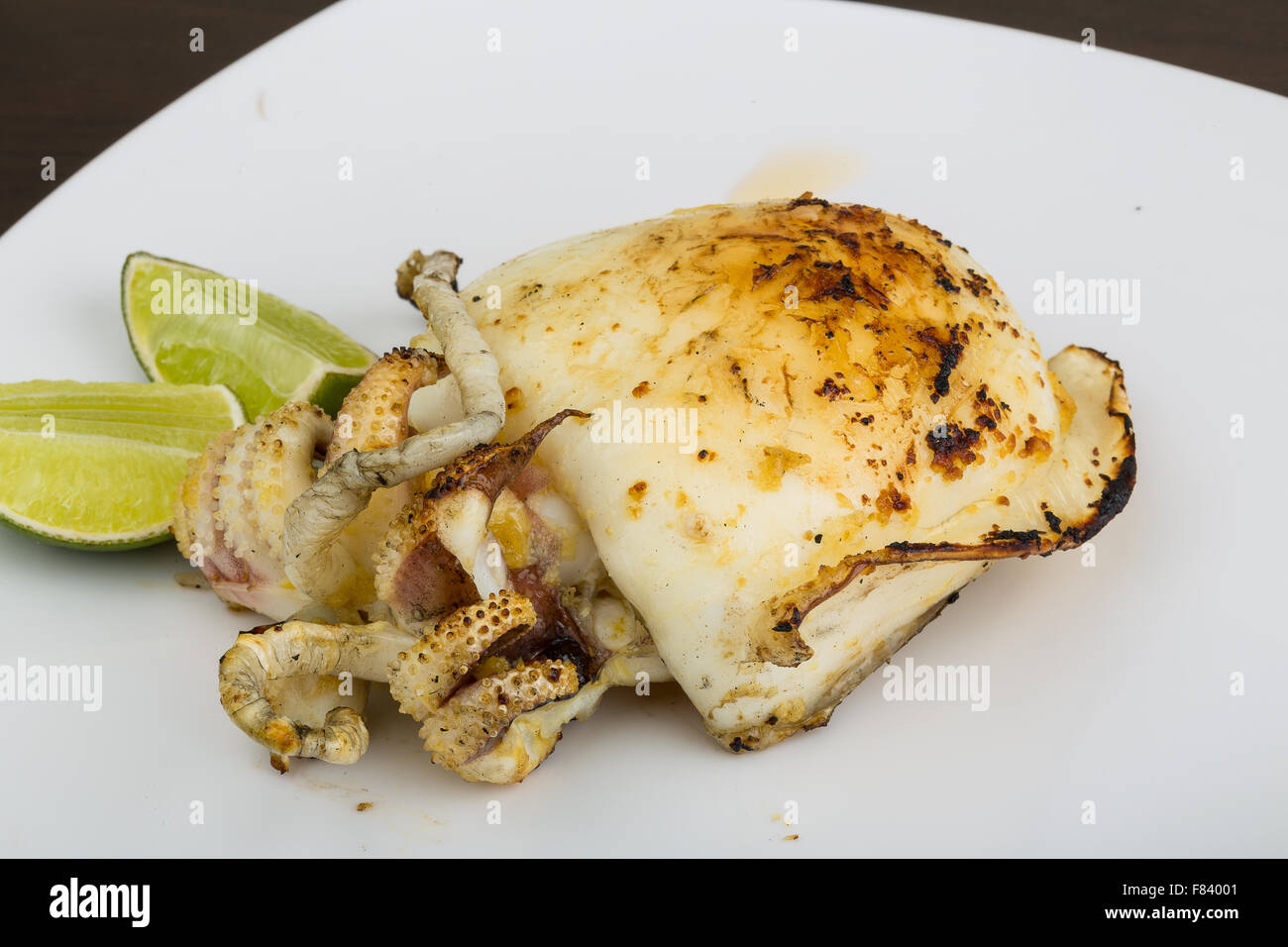 Grilled cuttlefish with lime on the wooden background Stock Photo - Alamy