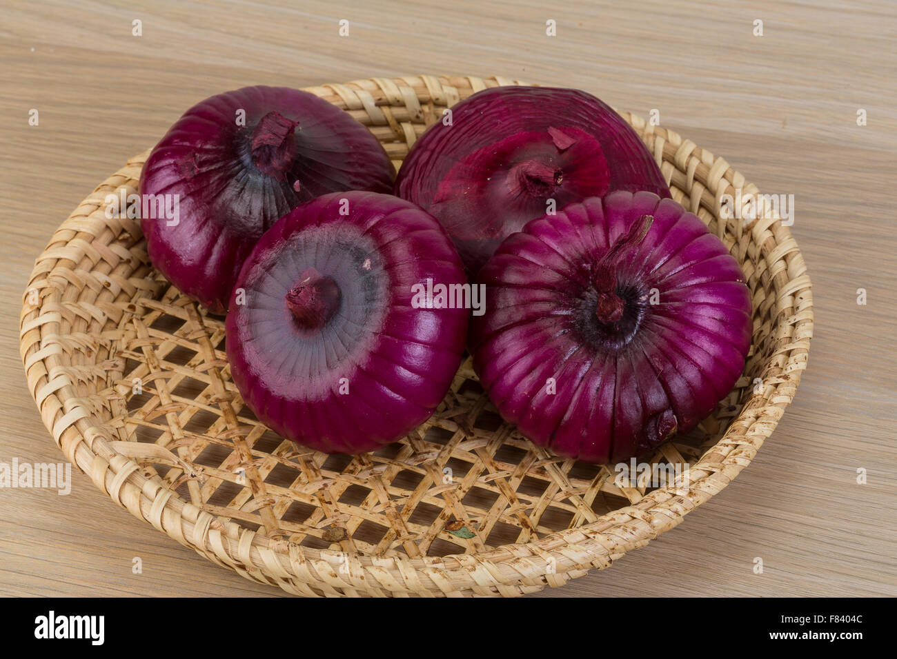 Violet onion in the basket with green Stock Photo - Alamy